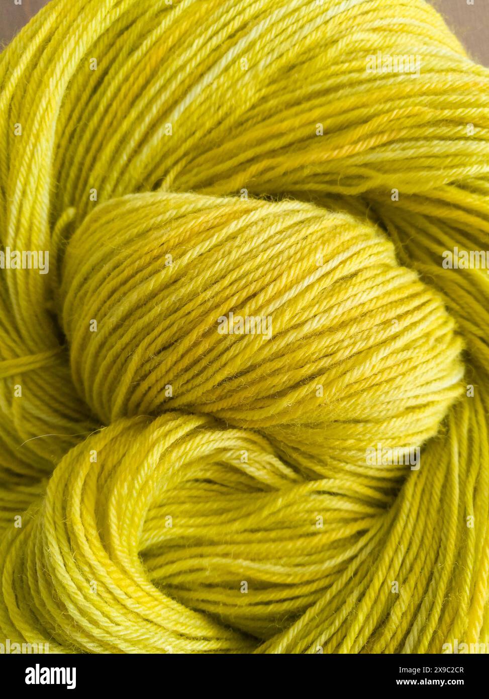 Close-up photo of twisted yellow-green hand dyed yarn hank Stock Photo ...