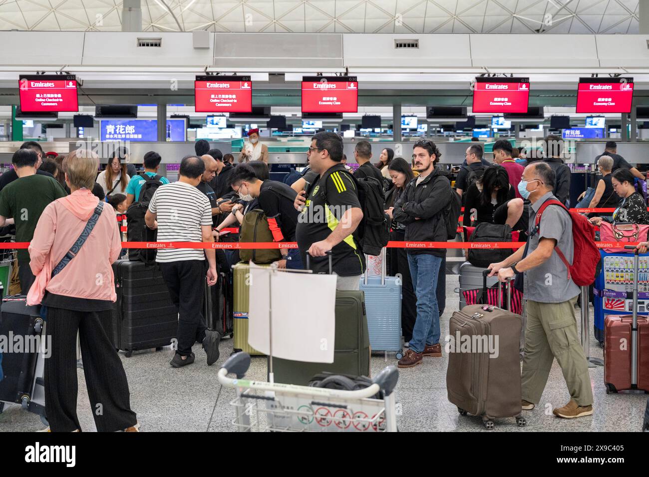 Passengers queue in line at the United Arab Emirates airline, Emirates ...