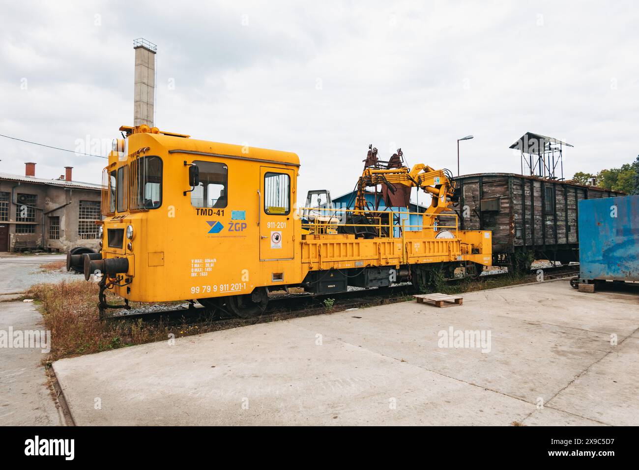 a bright yellow railway maintenance vehicle with a hydraulic crane on ...
