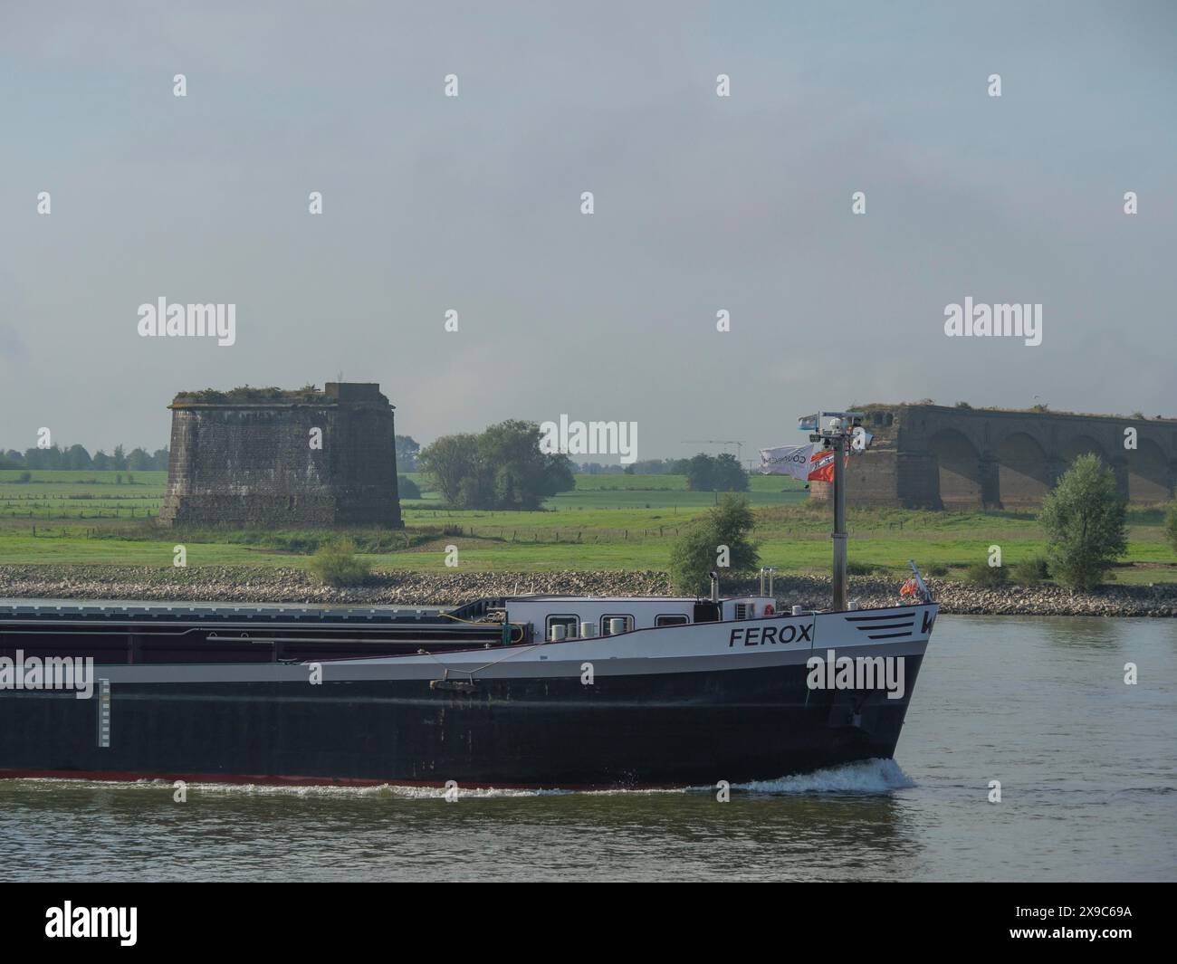 Old stone tower in the middle of a misty landscape by the water, the ...