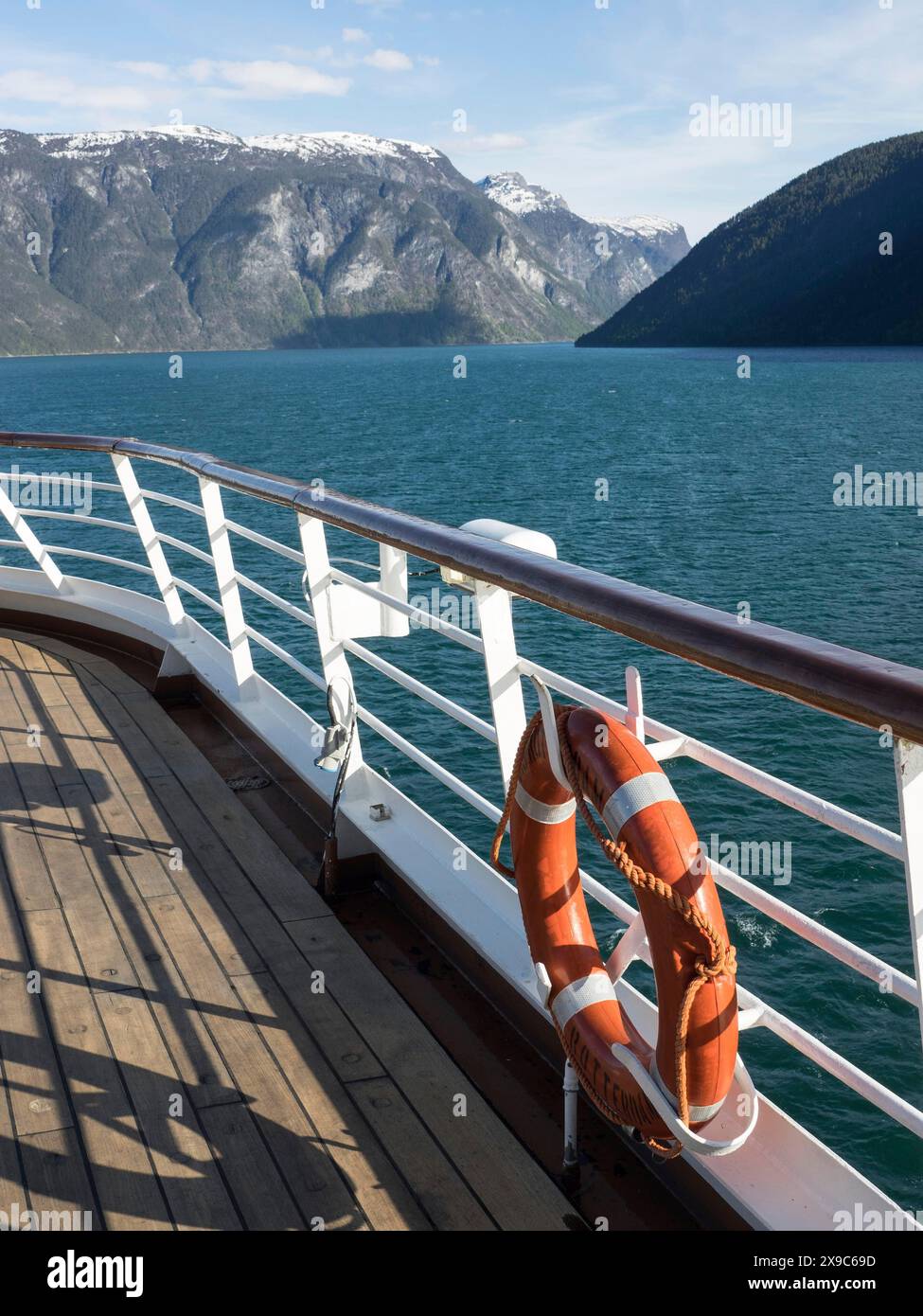 View from a ship on a calm fjord with snow-covered mountains in the ...