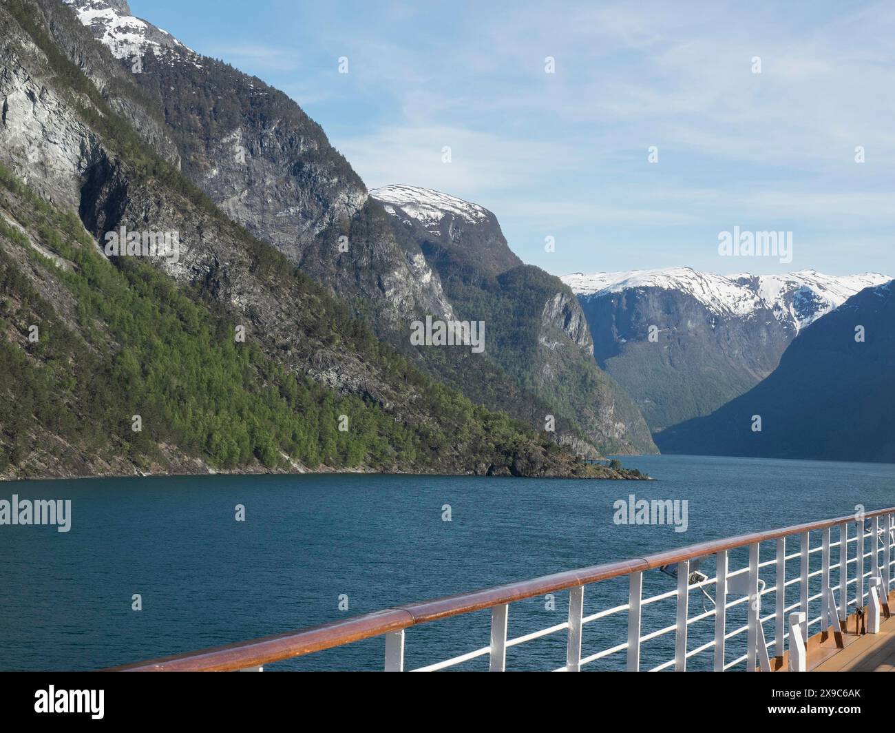 From the deck of a ship, a wide view of mountains and a deep fjord ...