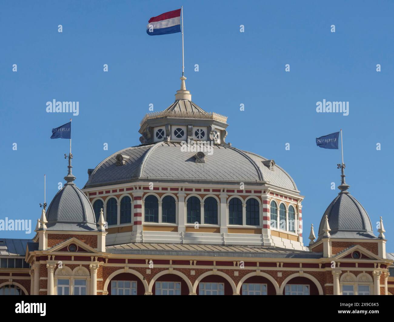 Historic building with Dutch flag and dome, parasols and a pier on the ...