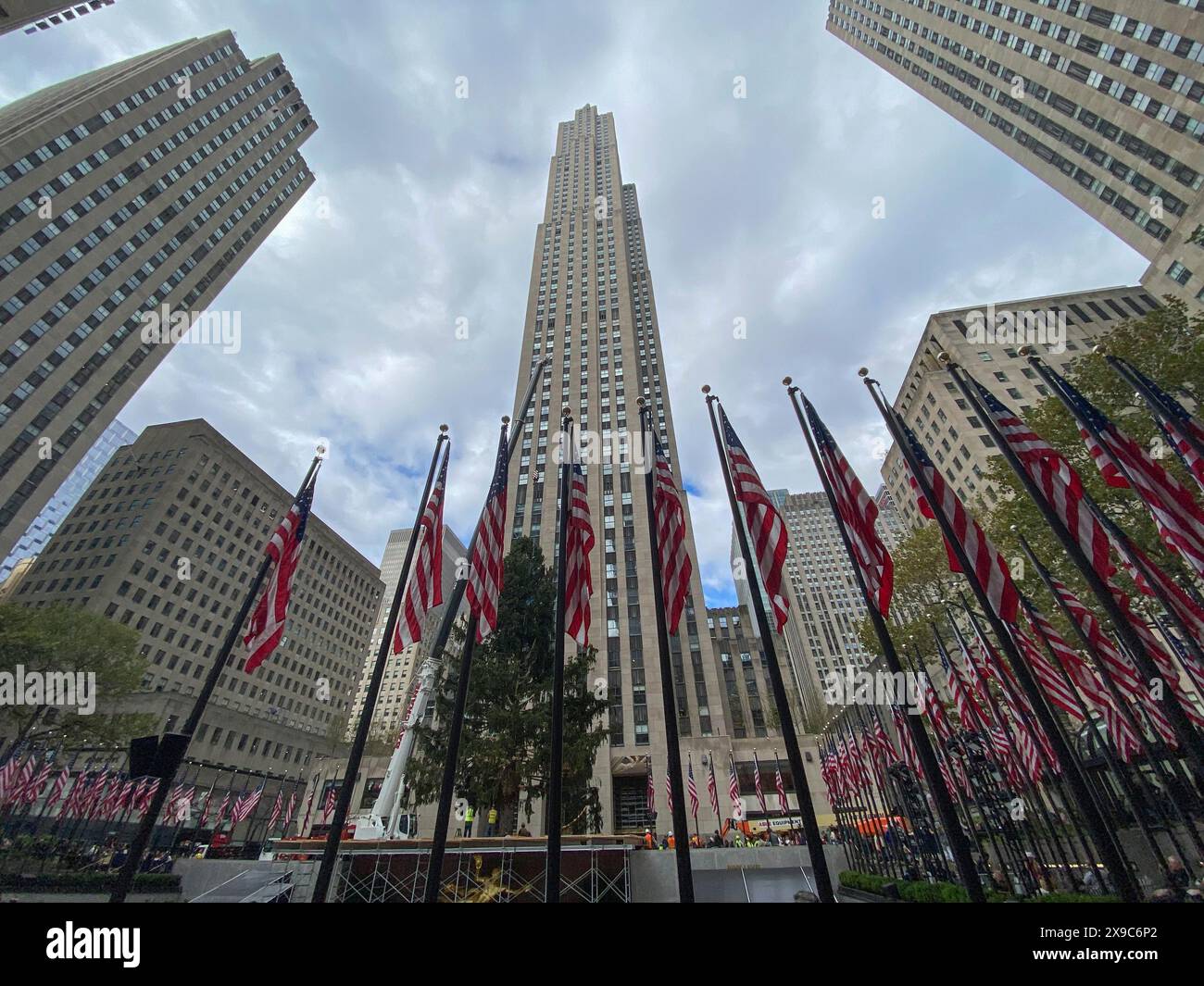 Tall skyscraper with several american flags in the foreground ...