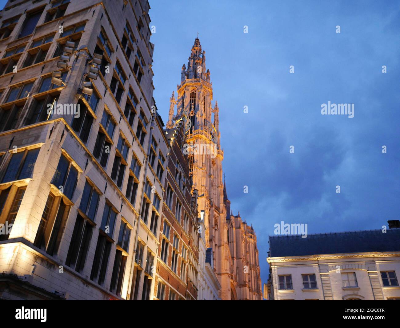Impressive gothic church tower surrounded by illuminated historic ...
