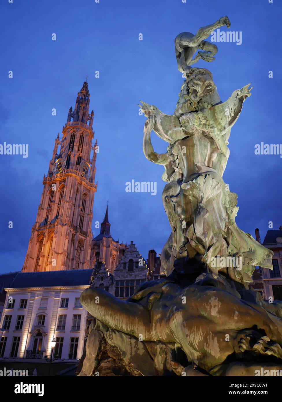 Detailed statue in front of an illuminated church tower and historic ...