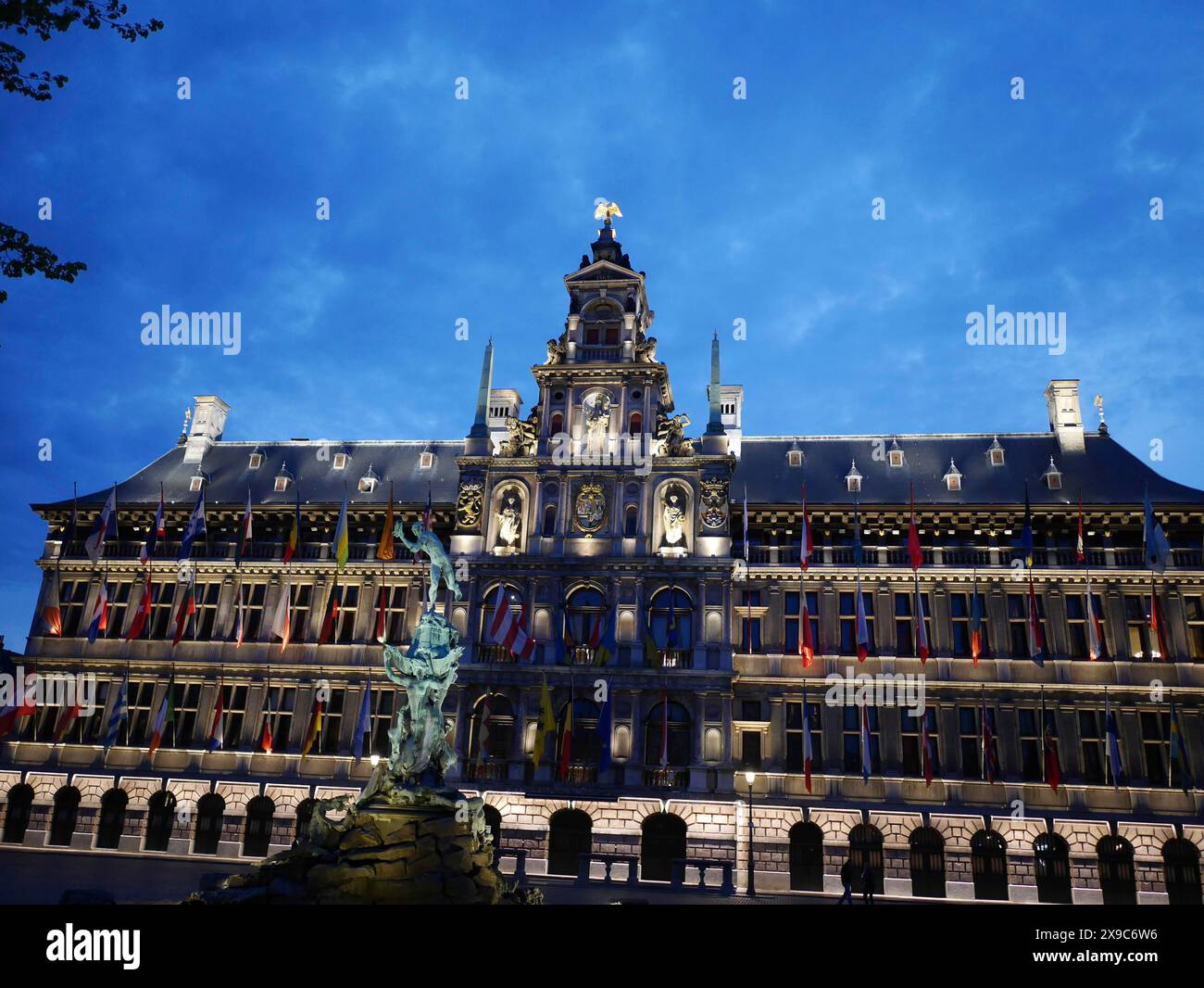 Luminous historic building with baroque architecture and flags at night ...