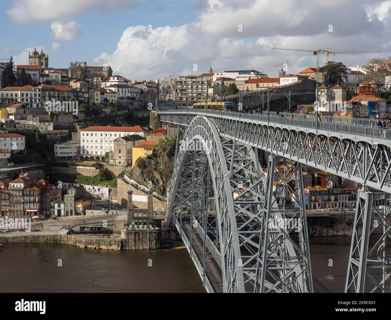 A large bridge crosses a river, behind it a historic cityscape under a ...