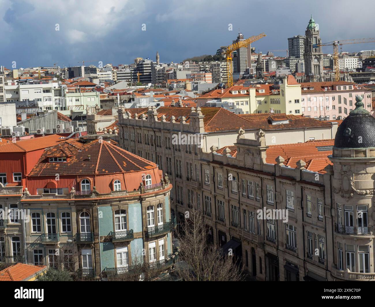 View of a city with red roofs, construction cranes and historic ...