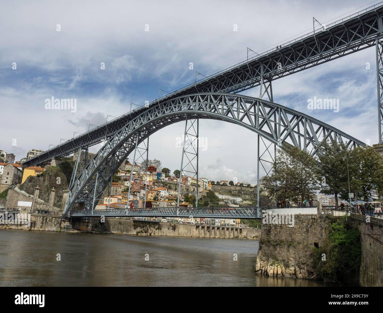 Large iron bridge crossing a river with a neighbourhood in the ...