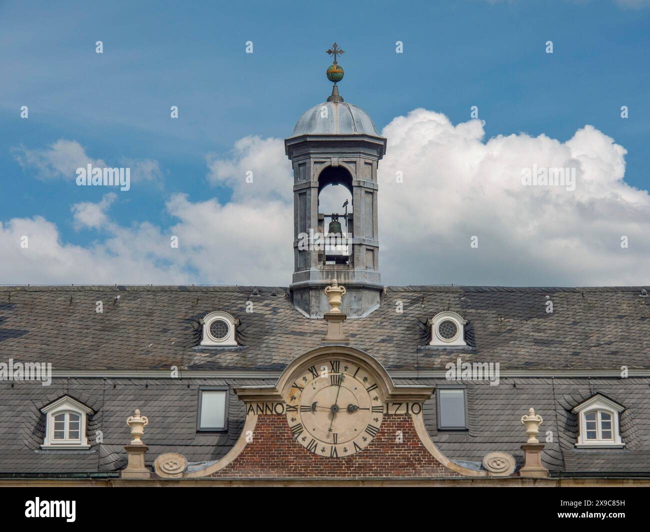 A clock tower on a historic castle under a blue sky with white clouds ...