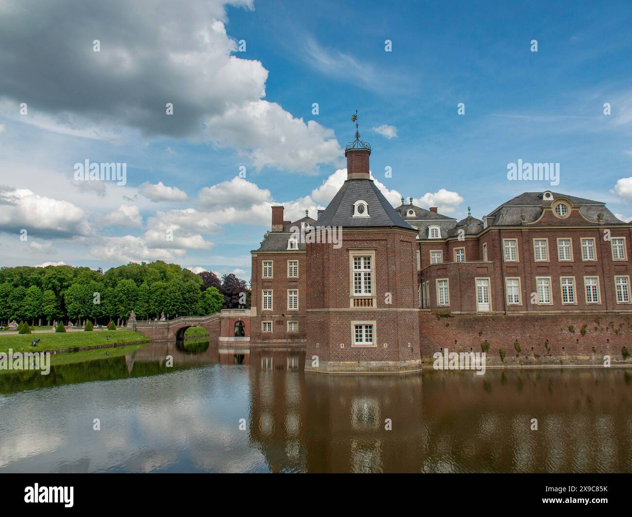 Historic red brick castle, situated on a moat with a small bridge ...