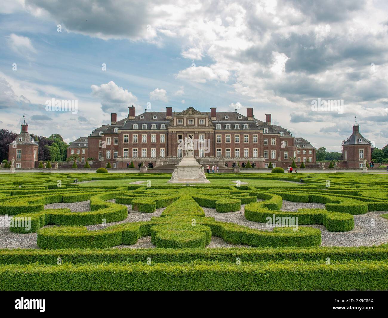 Historic castle with decorative hedges and manicured garden under a ...