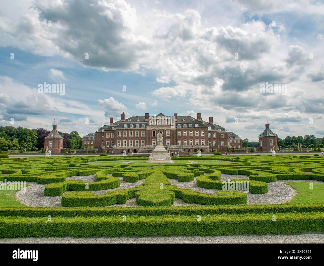 Large historic castle with manicured hedges forming a labyrinth under a ...