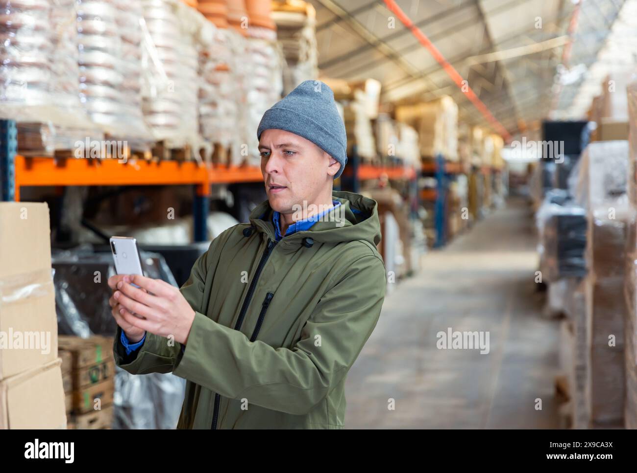 Store warehouse employee scans barcode on boxes using phone Stock Photo ...