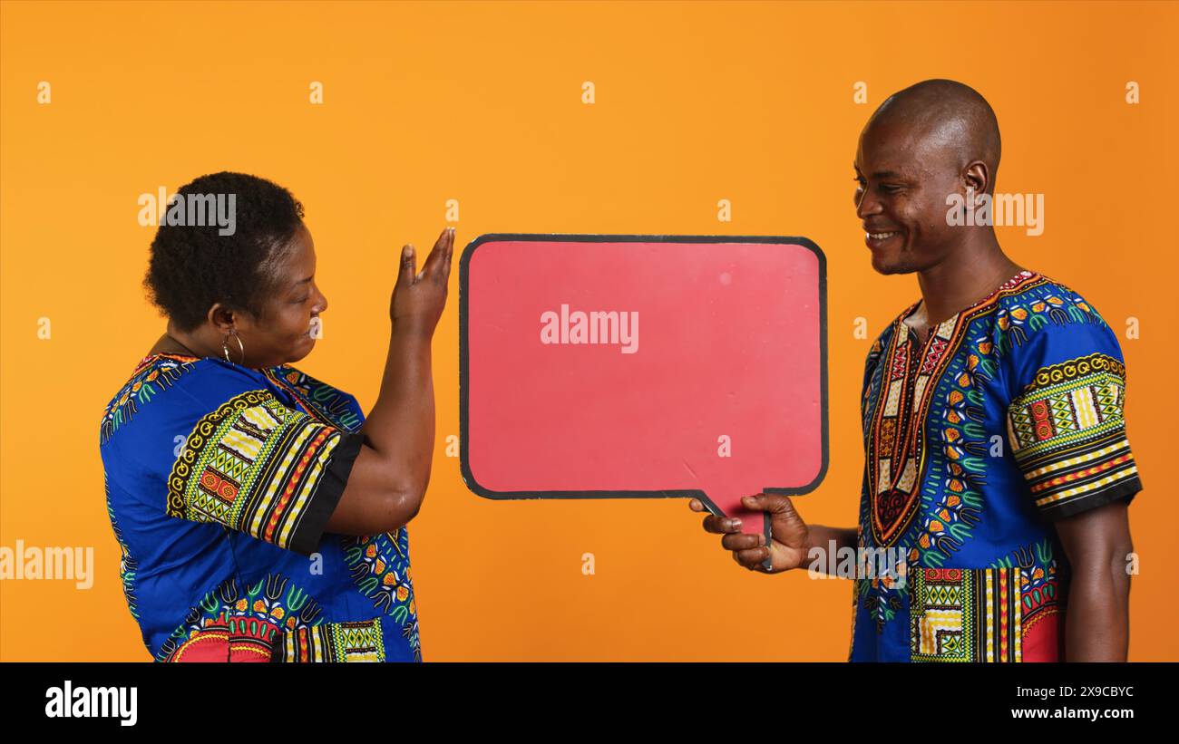 Married ethnic people pointing at red speech bubble icon made from ...