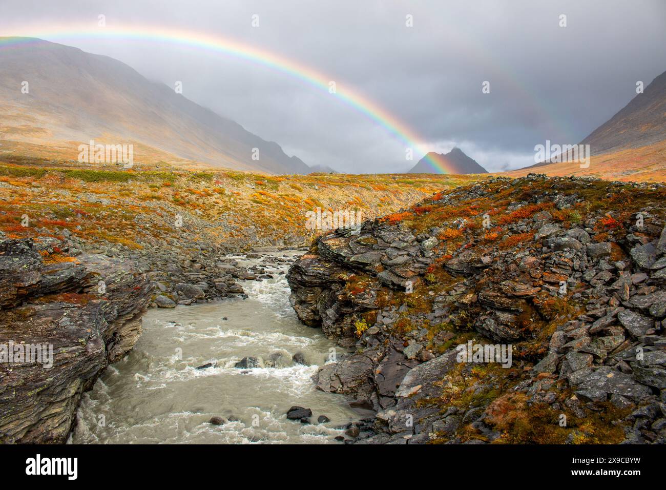 A rainbow above Guobirjohka river that crosses Kungsleden hiking trail ...