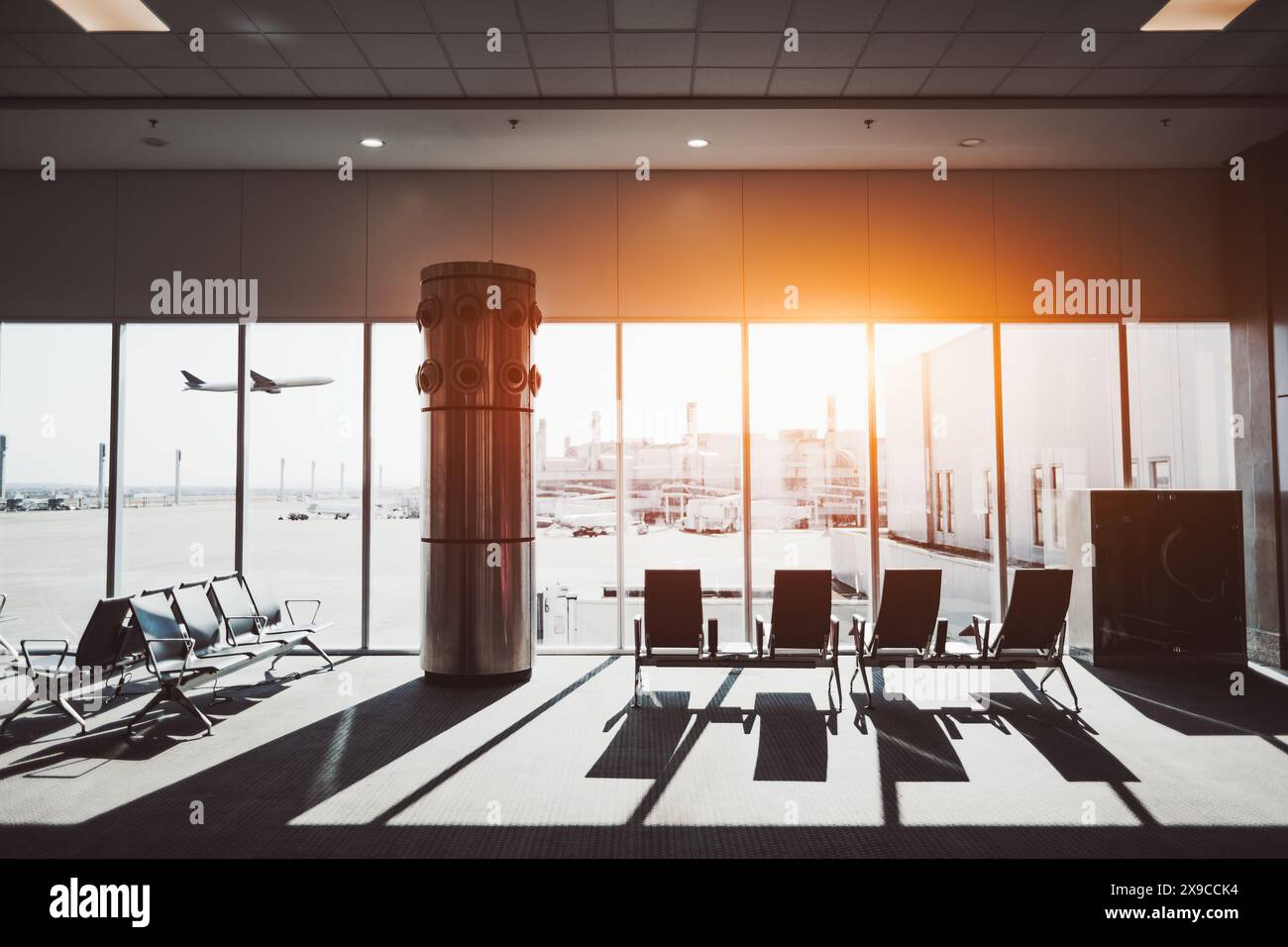 Interior of an airport terminal with empty seating areas, large glass ...