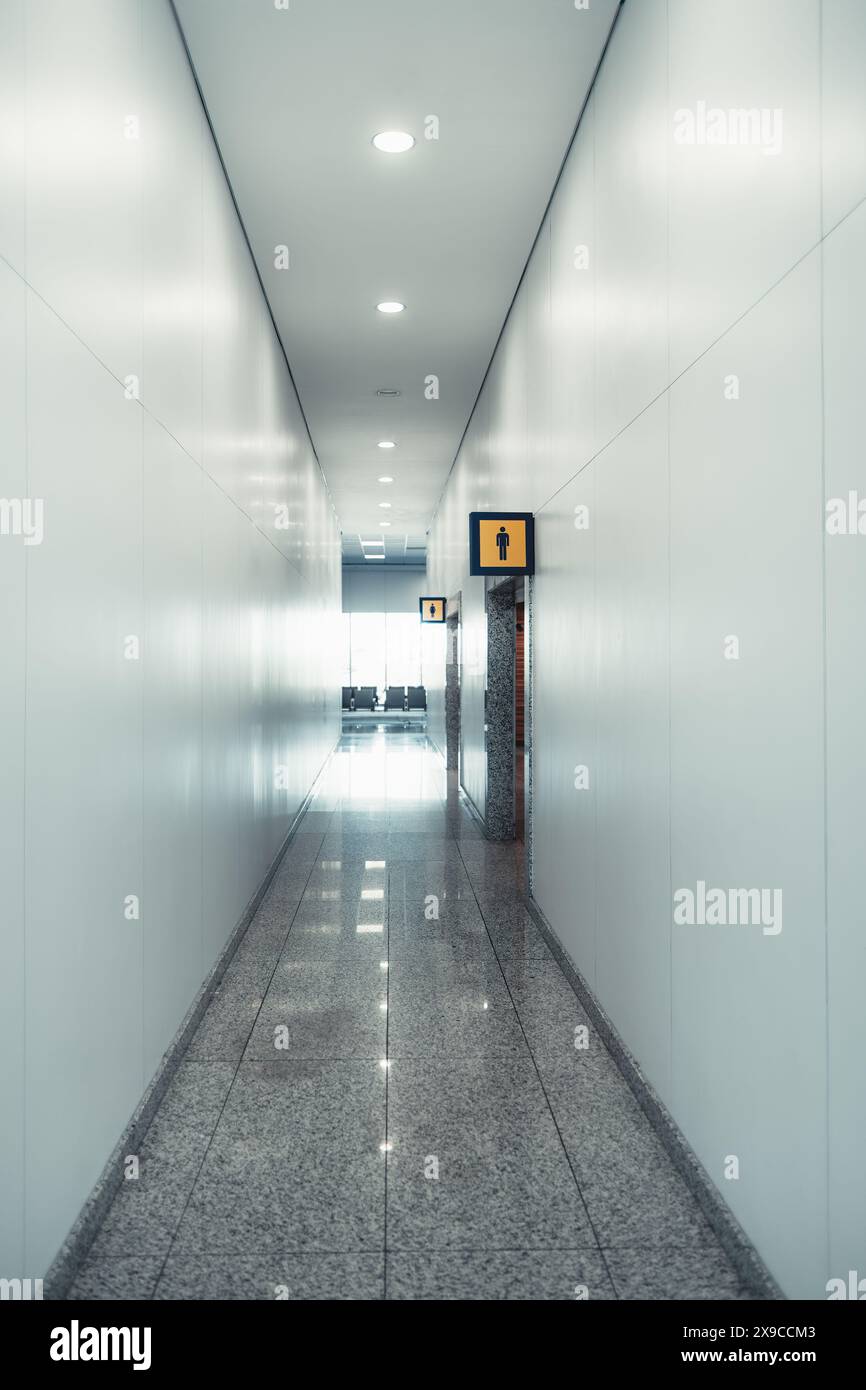 A vertical shot of a clean, modern airport corridor leading to a ...