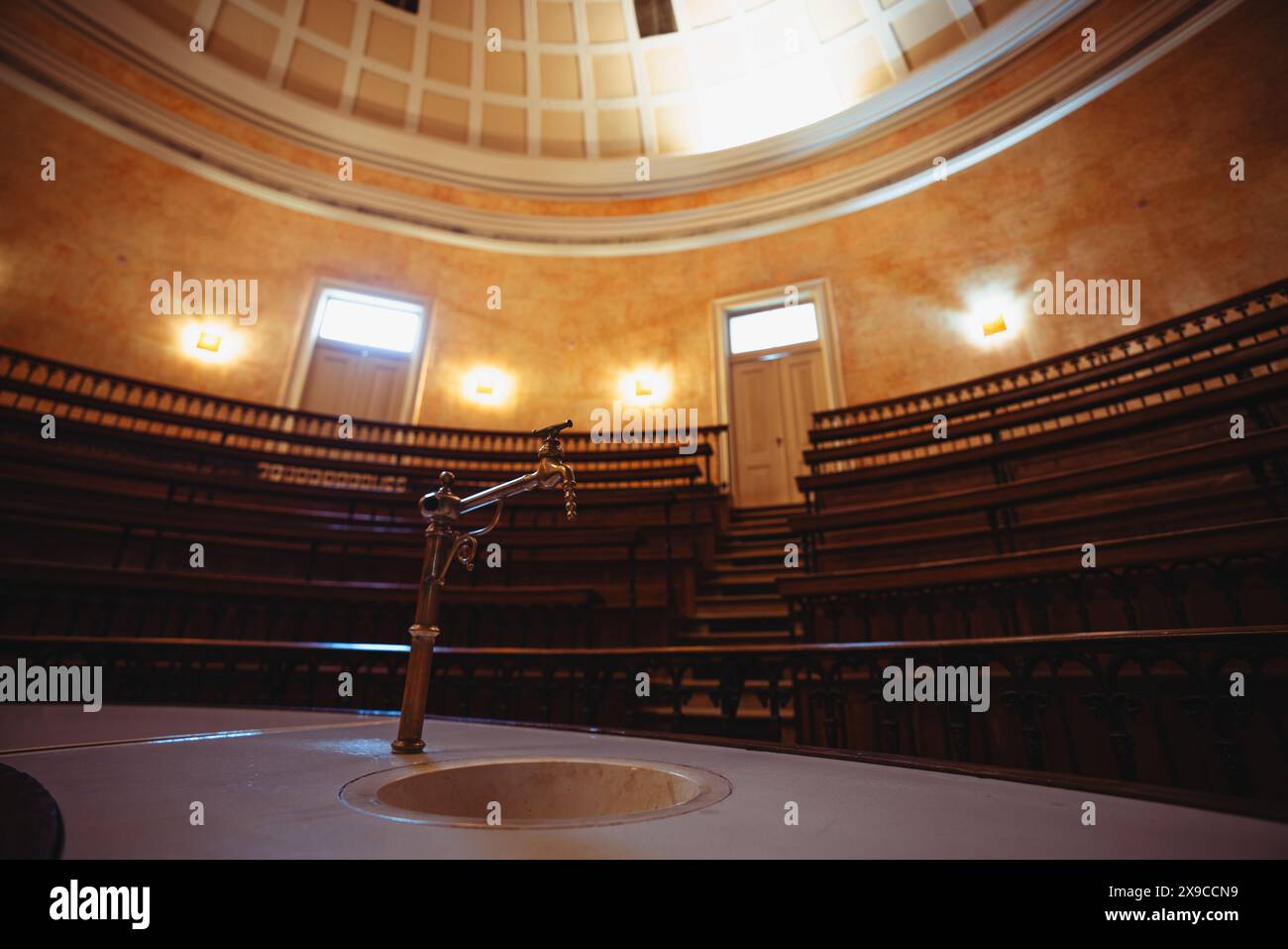 Low-key interior of a historic lecture hall with tiered wooden seating ...
