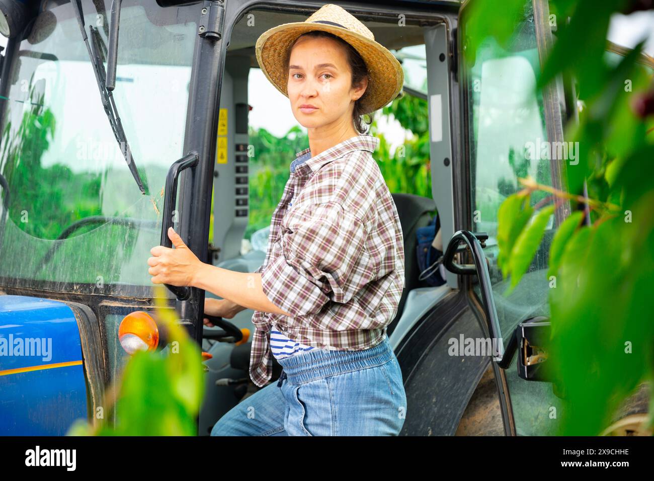 Portrait of female worker working on tractor Stock Photo - Alamy