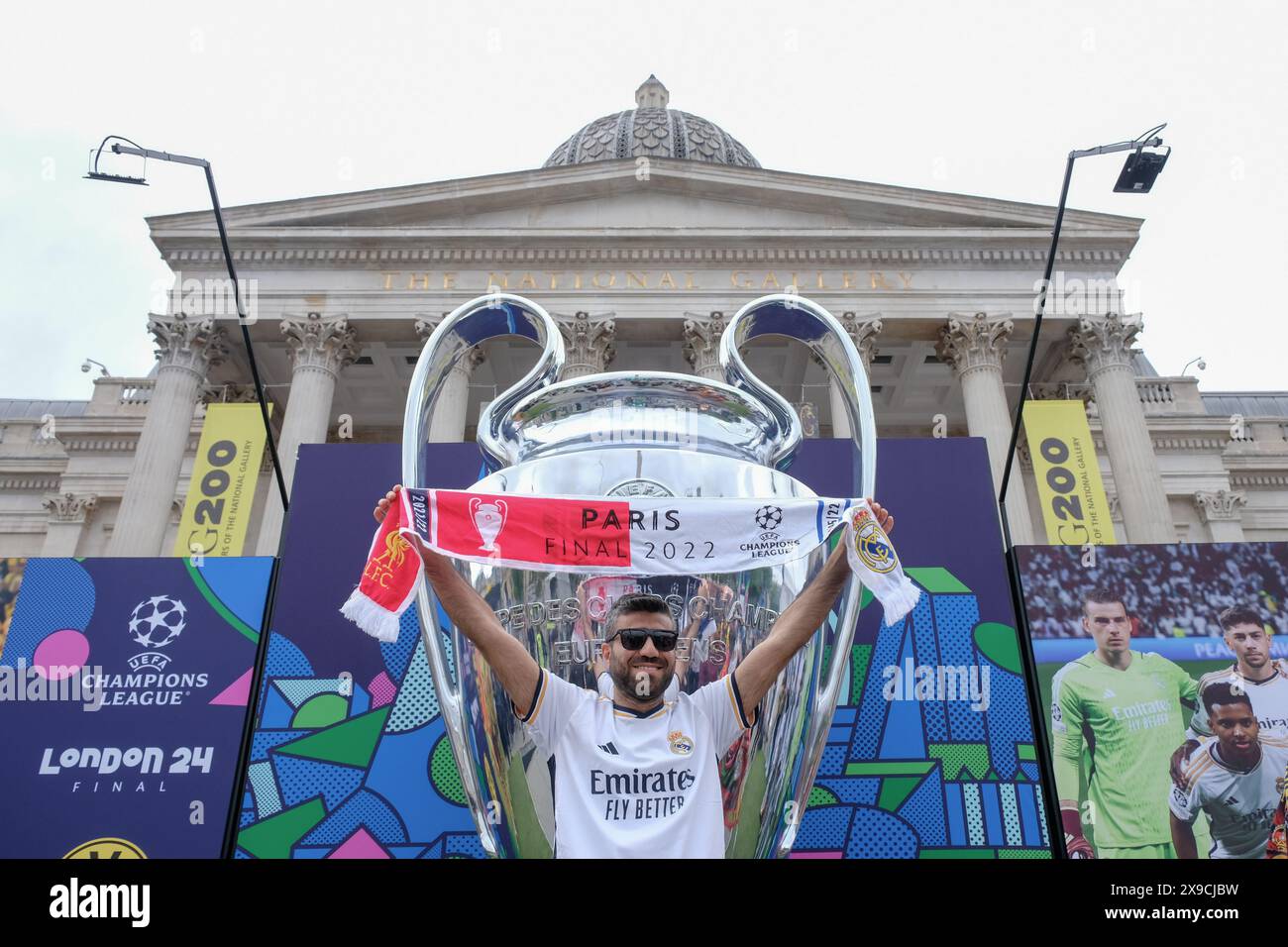London, UK. A Real Madrid fan poses in front of a giant trophy with a ...