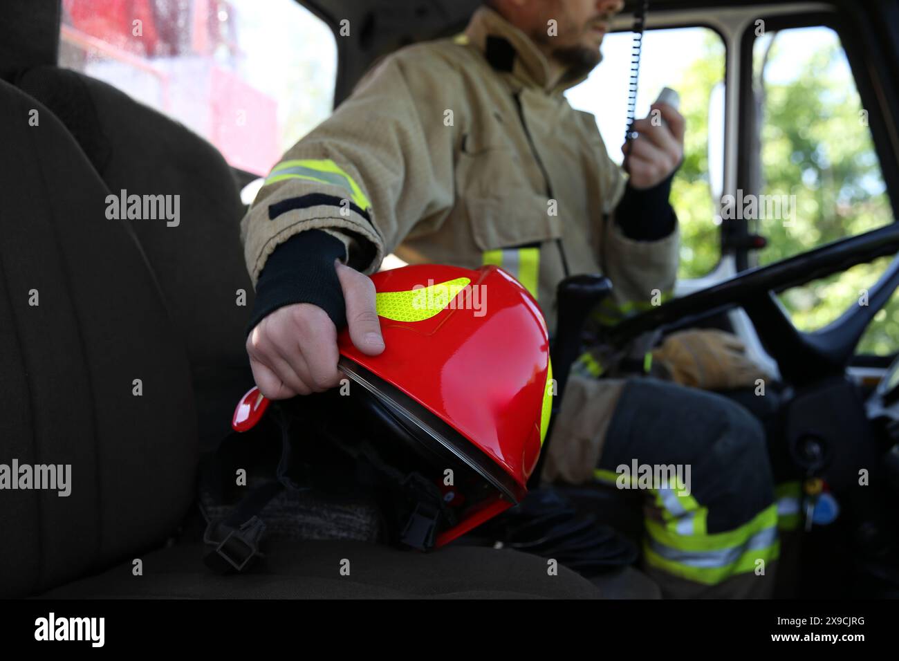 Firefighter using portable radio set while driving fire truck ...