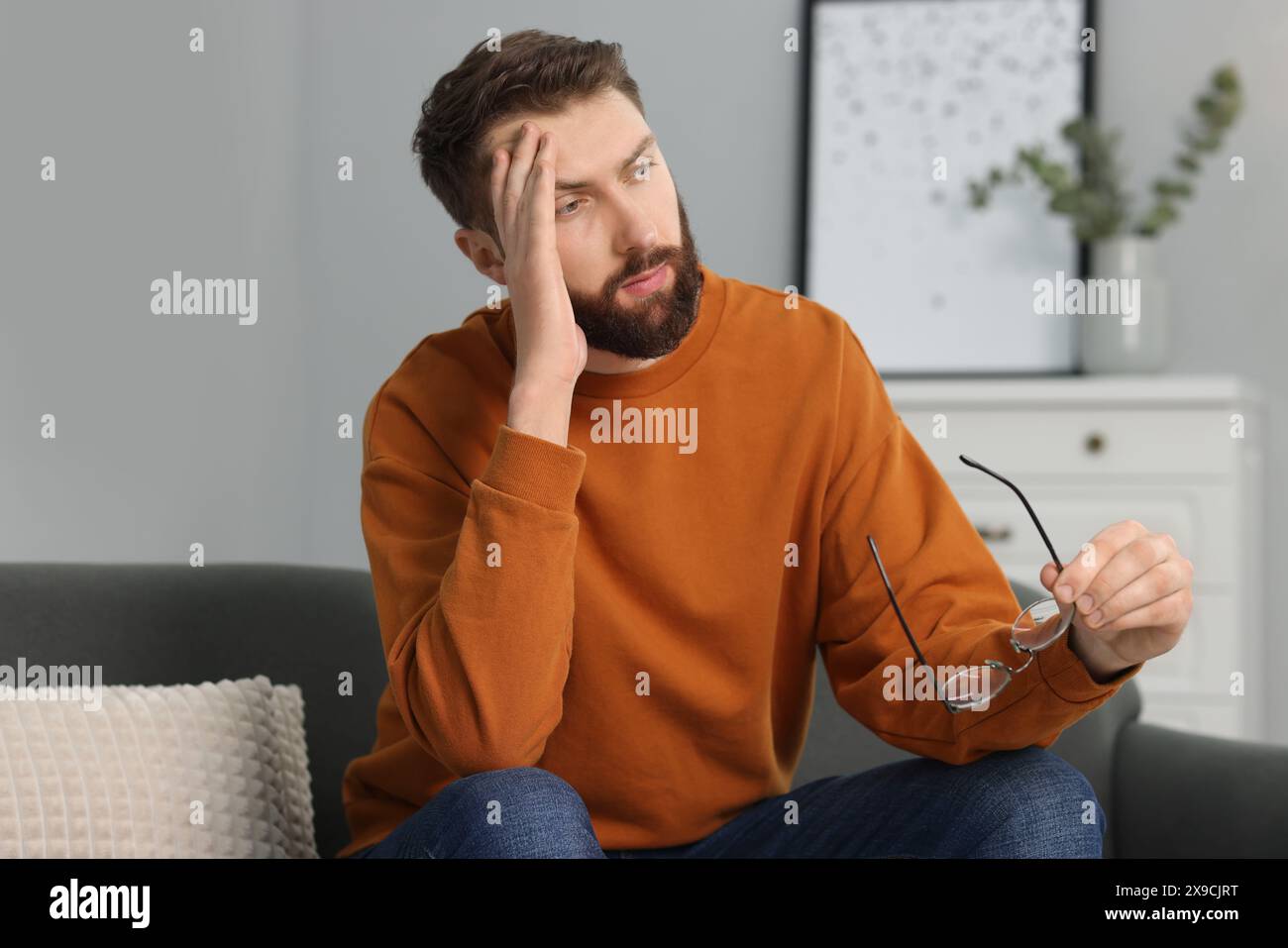 Overwhelmed man with glasses suffering at home Stock Photo - Alamy