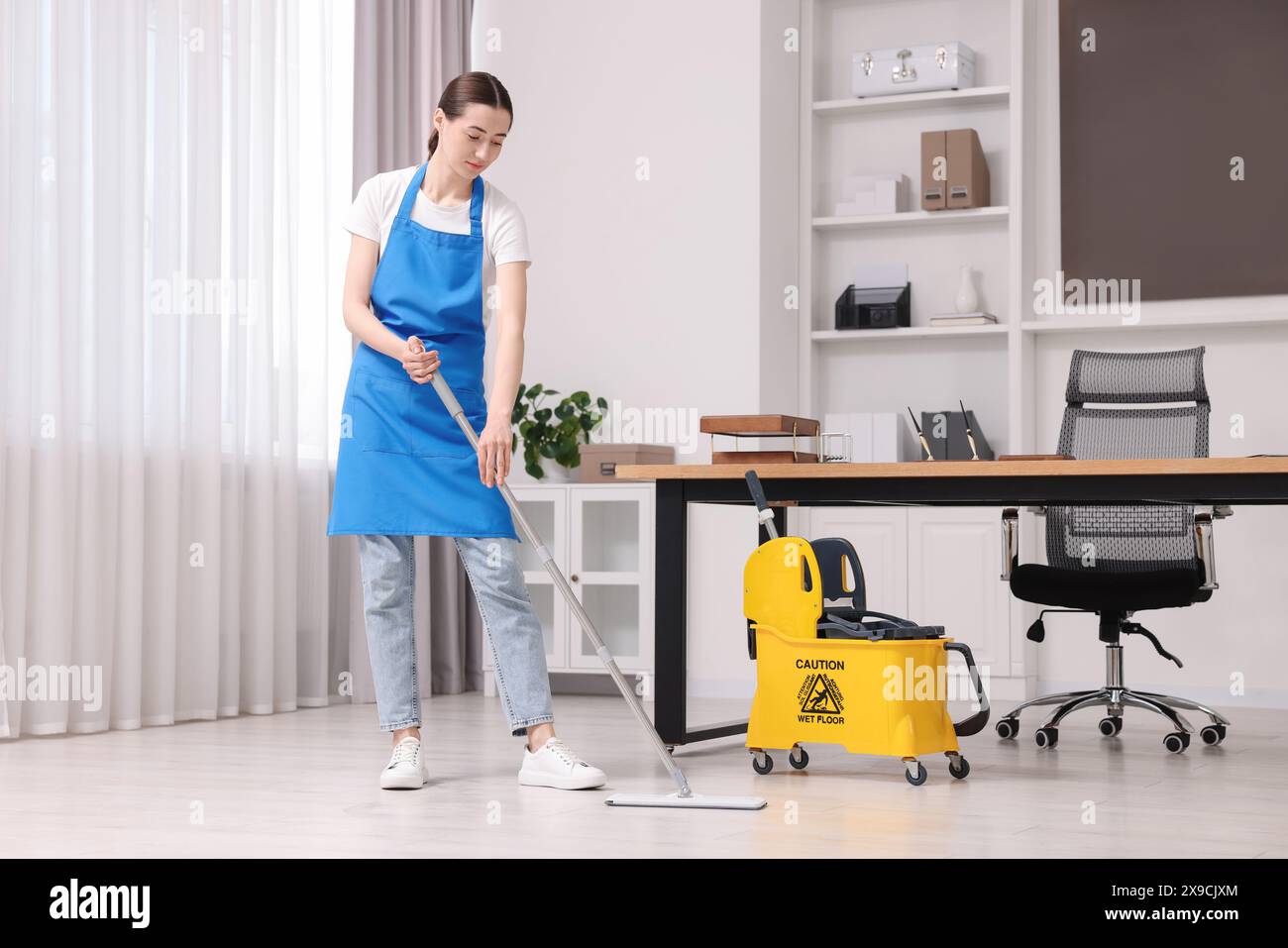Cleaning service. Woman washing floor with mop in office Stock Photo ...