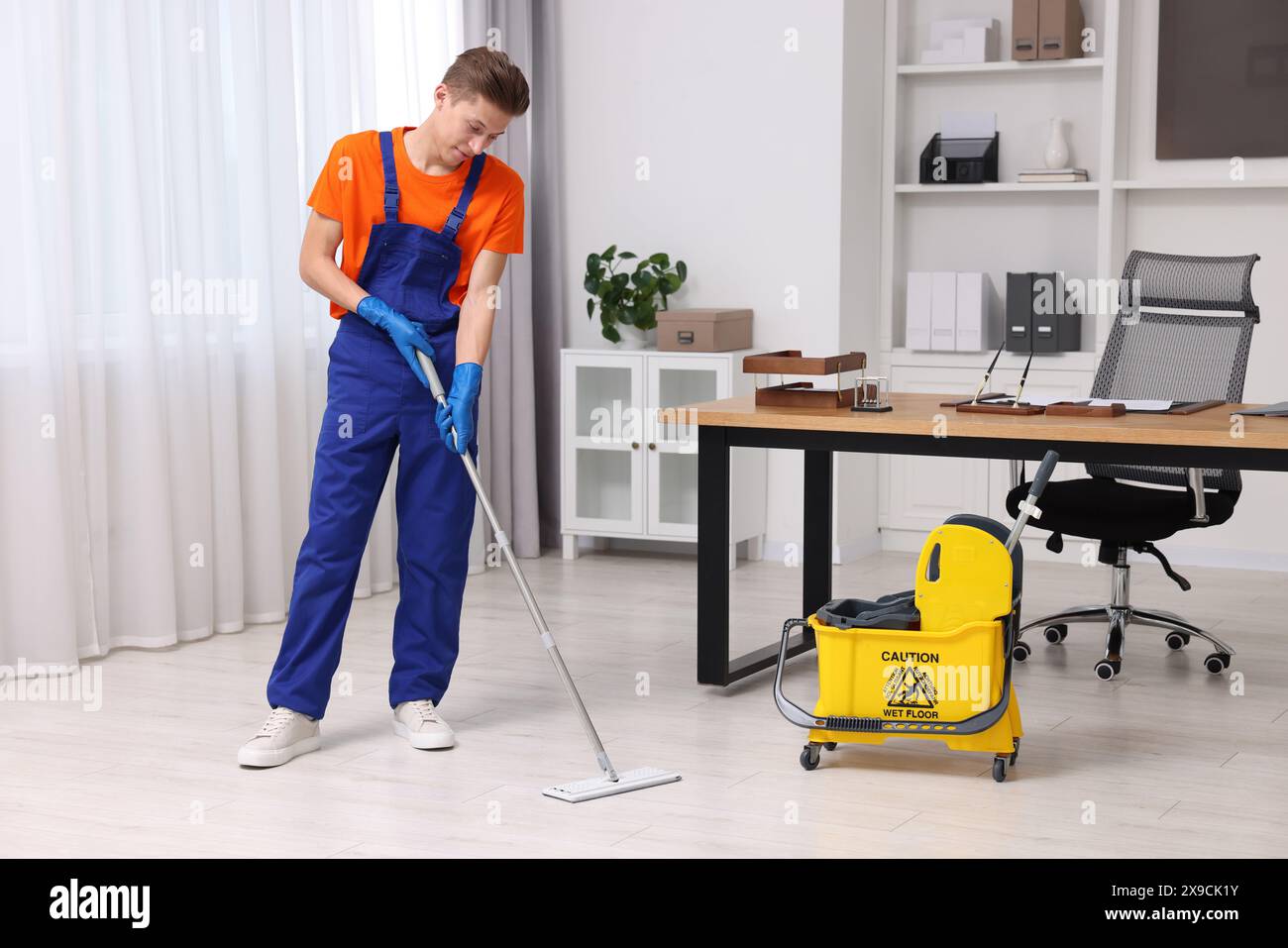 Cleaning service. Man washing floor with mop in office Stock Photo - Alamy