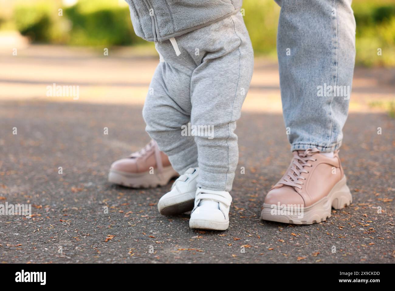 Mother teaching her baby how to walk outdoors, closeup Stock Photo - Alamy