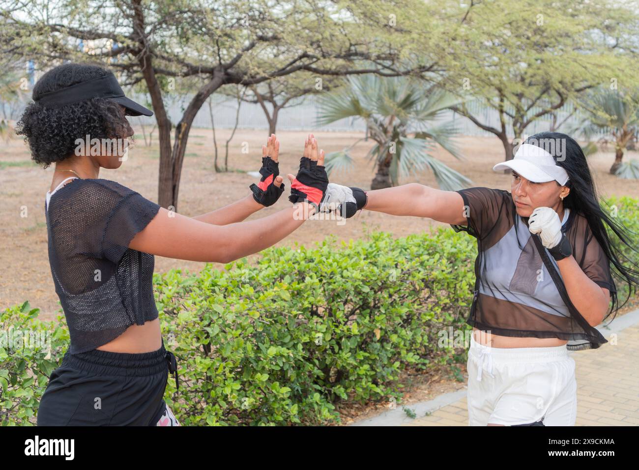 Two women engaged in a sparring session during martial arts practice in ...