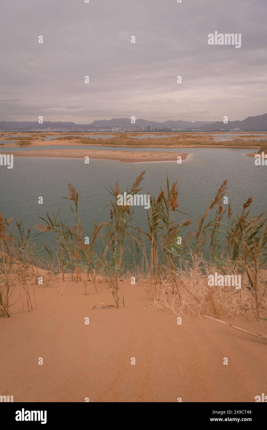 Desert vastness next to lake in Wuhai, Inner Mongolia, China. Dramatic ...