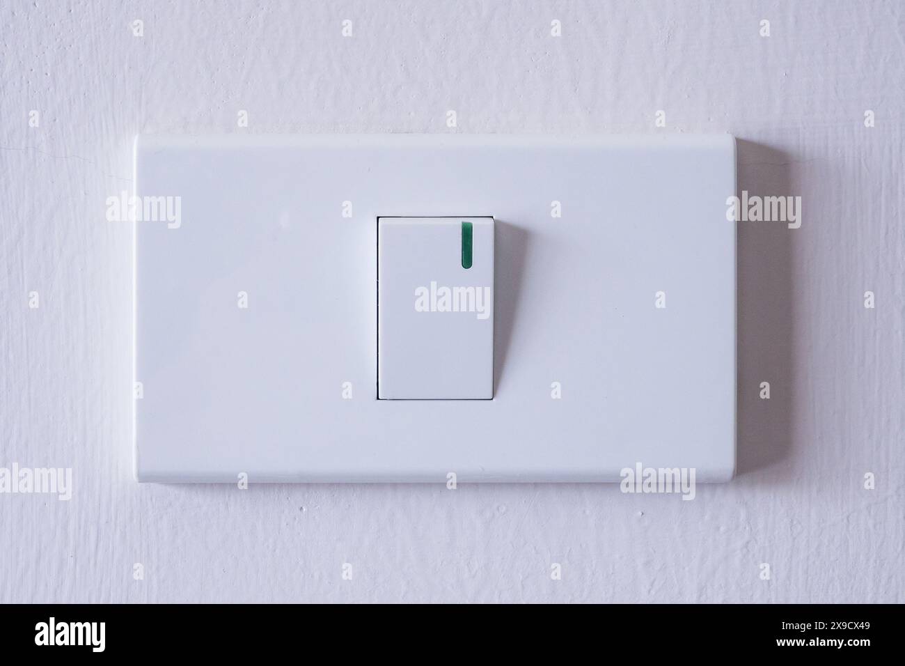 room light switch on white concrete wall Stock Photo - Alamy
