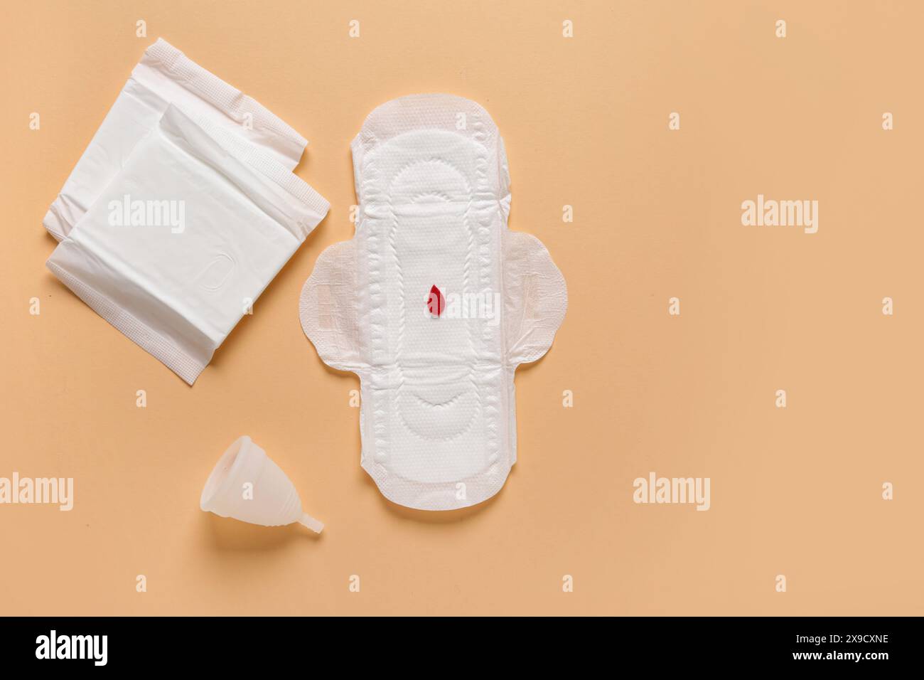 Menstrual pads with cup and paper blood drop on beige background Stock ...