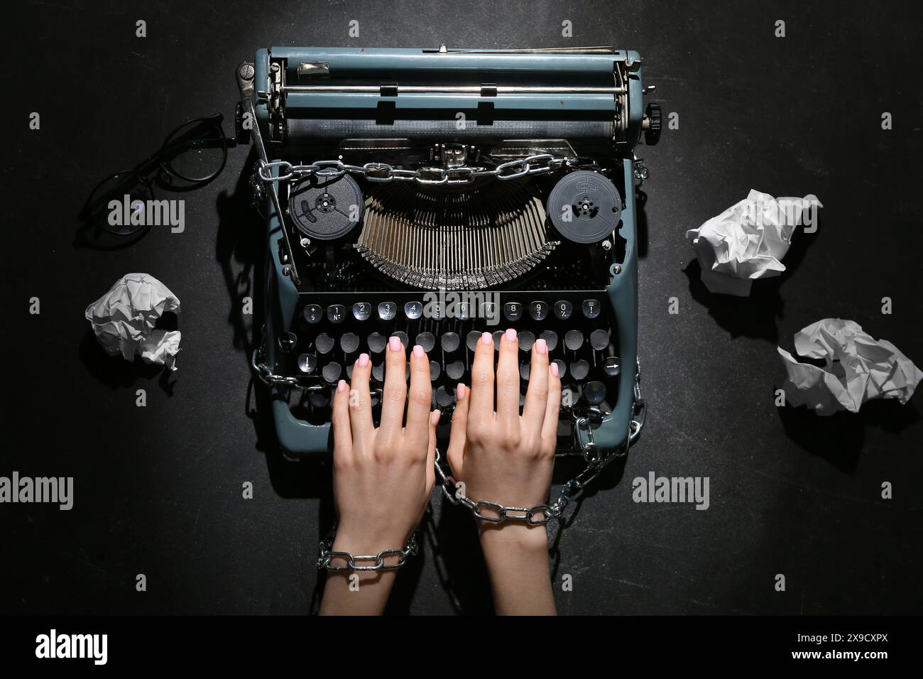 Female hands with vintage typewriter, chains and crumpled paper on ...