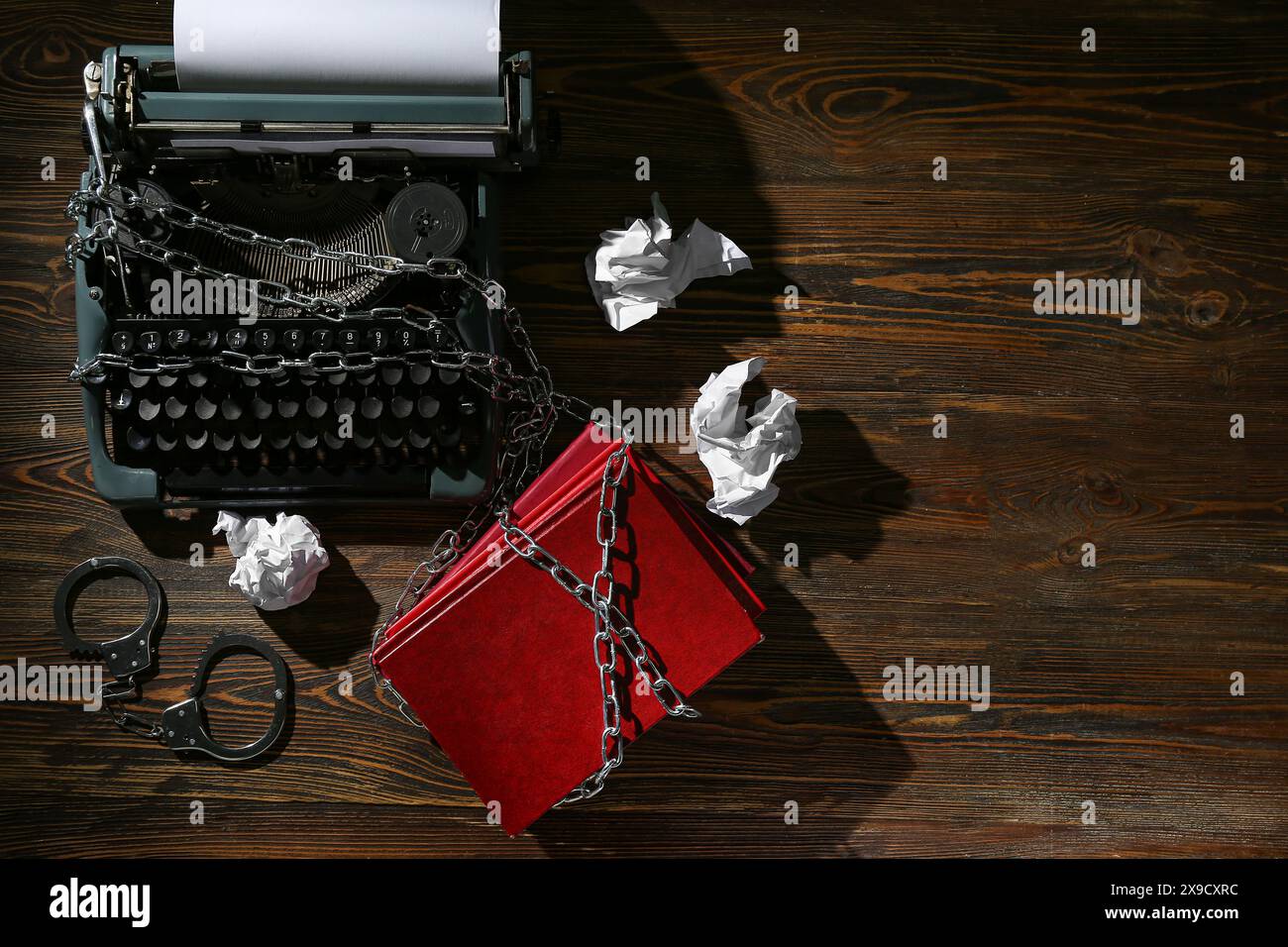 Vintage typewriter with chains, books and crumpled paper on wooden ...