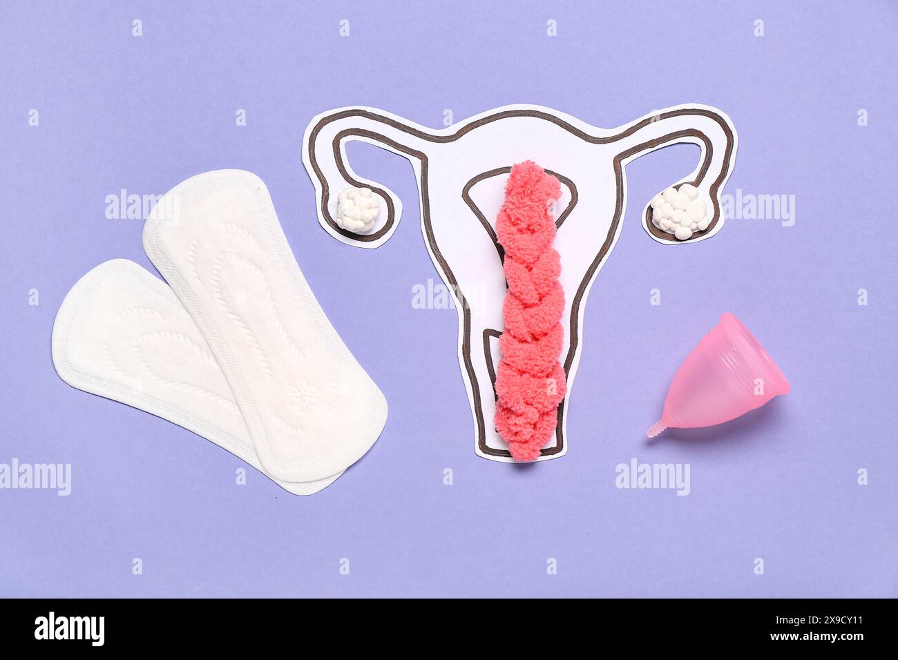 Paper uterus with menstrual pads and cup on purple background Stock ...