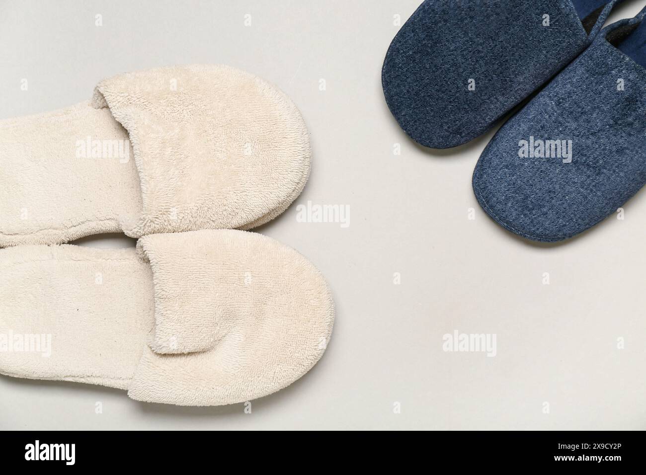 Two pairs of slippers on grey background. Top view Stock Photo - Alamy