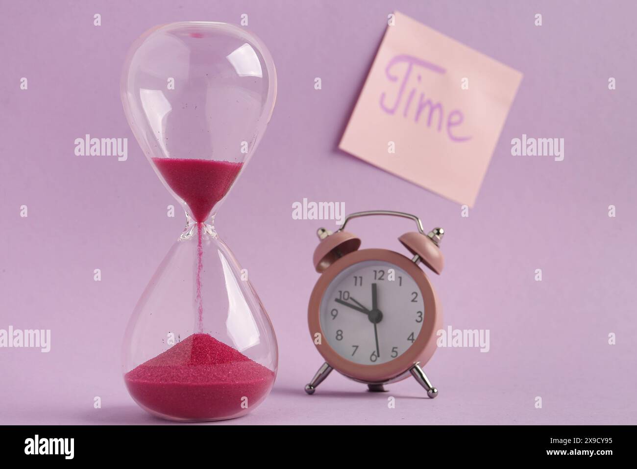 Sticky note with word TIME, hourglass and alarm clock on lilac ...