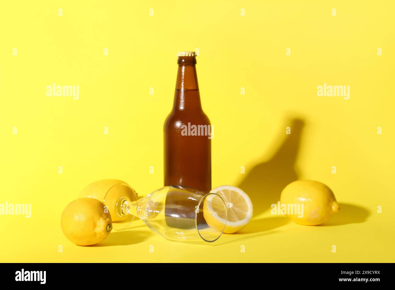 Bottle of fresh beer with lemons on yellow background Stock Photo - Alamy