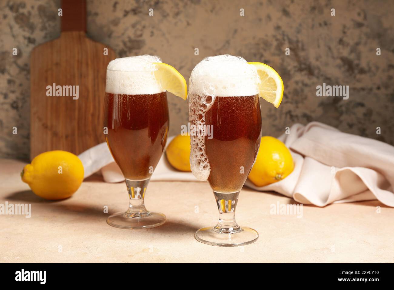 Glasses of fresh beer with lemon on beige background Stock Photo - Alamy