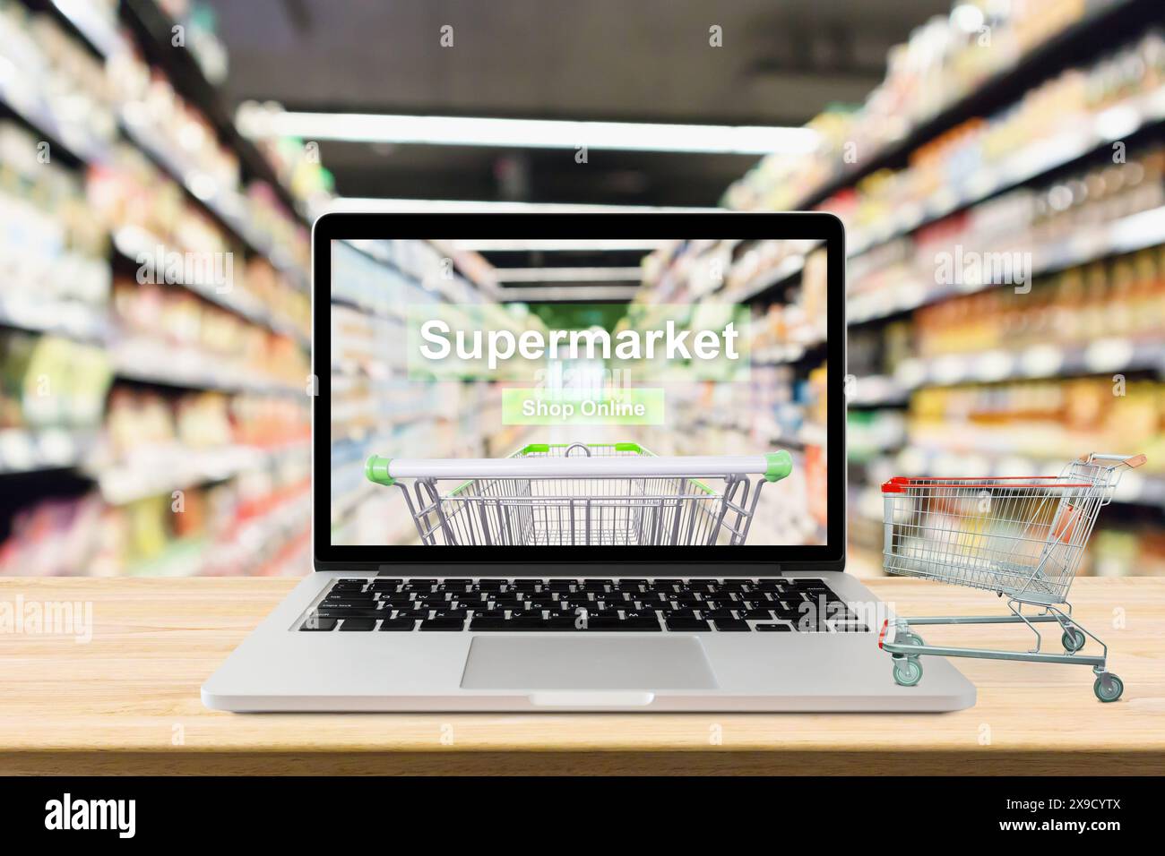 laptop computer on wood table with supermarket aisle blurred background ...
