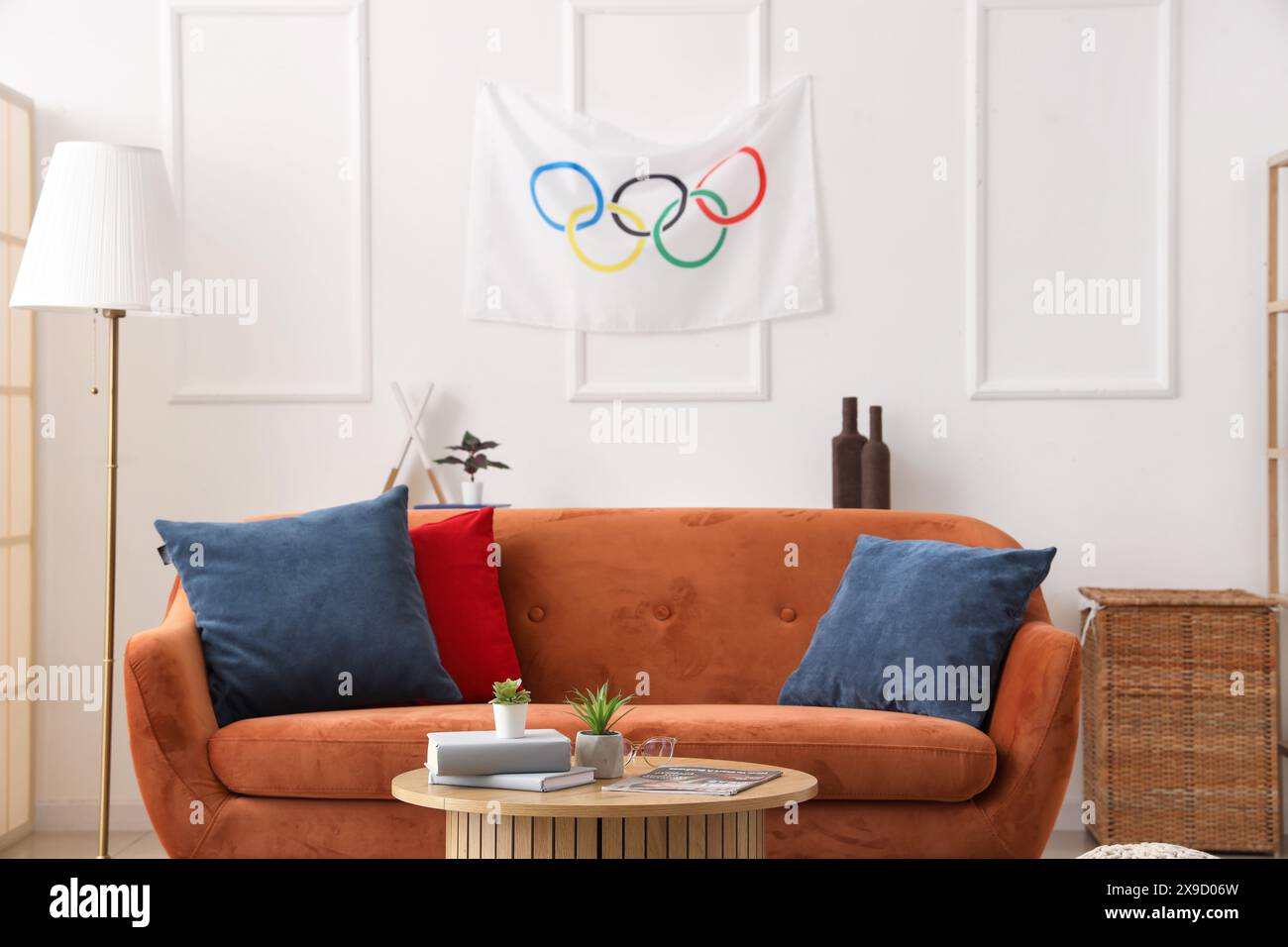 Interior of living room with brown sofa, coffee table and Olympic flag ...