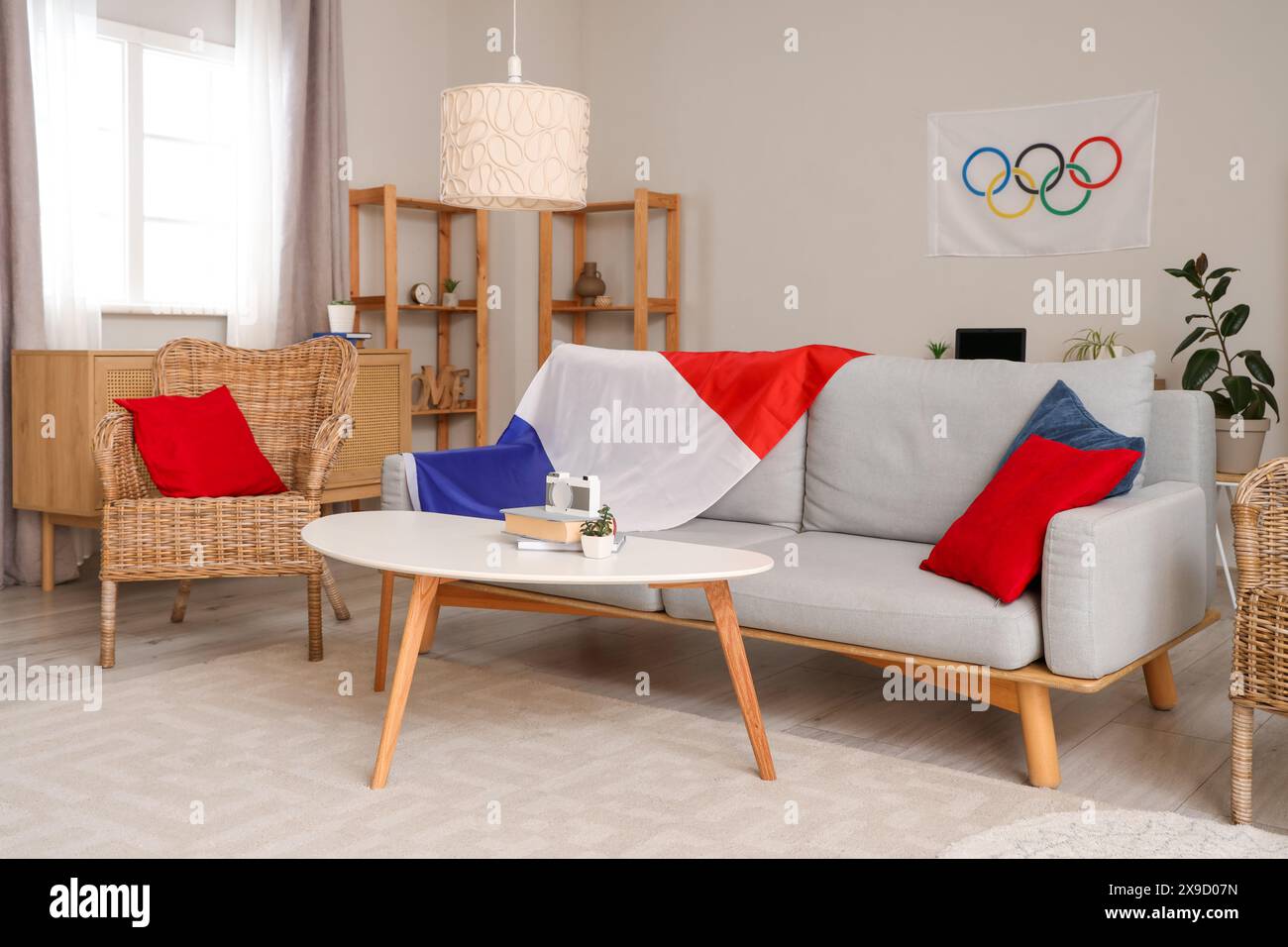 Interior of living room with grey sofa, wicker armchair, coffee table ...