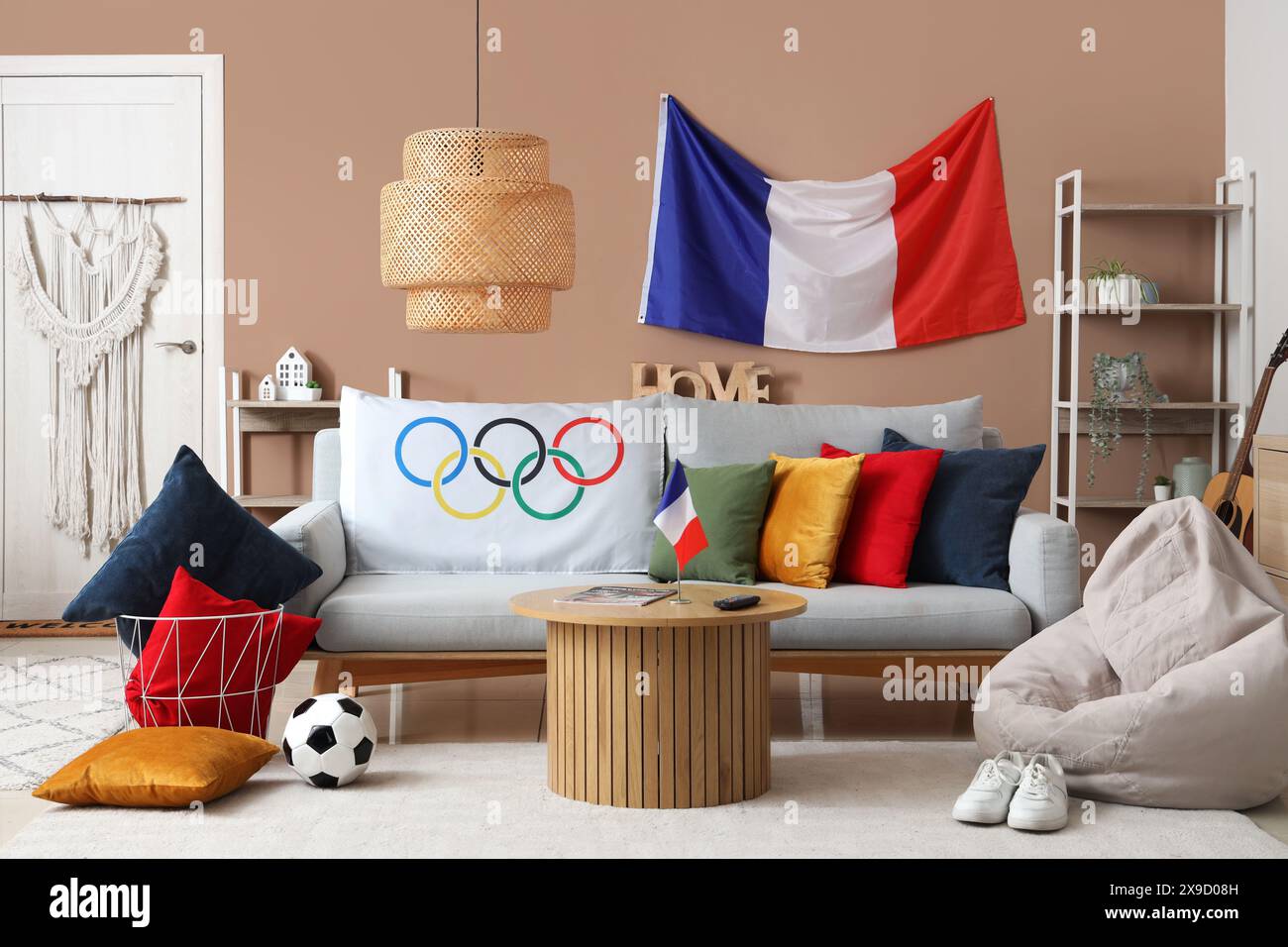 Interior of living room with grey sofa, soccer ball, Olympic and French ...