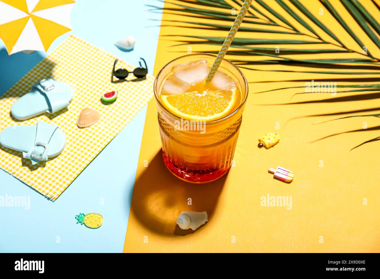 Glass of tasty cocktail with umbrella, flip flops, shells, sunglasses ...