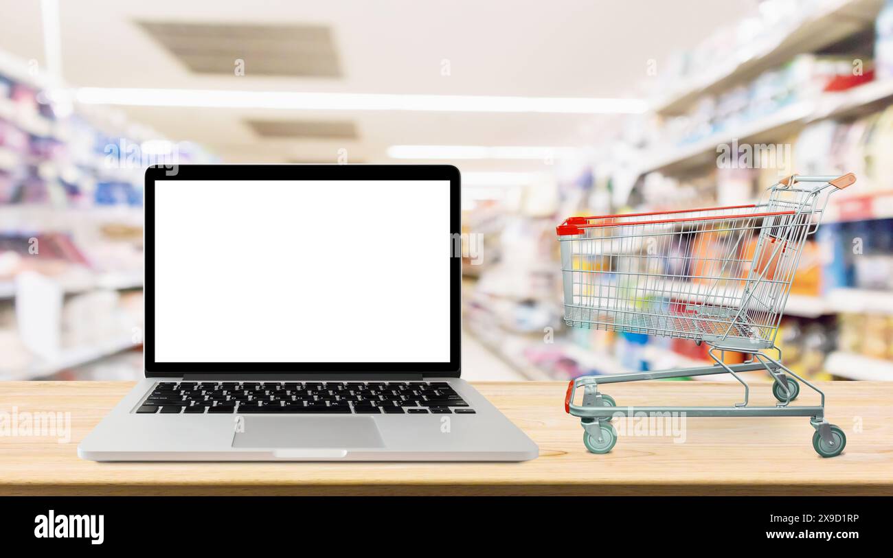 laptop computer on wood table with supermarket aisle blurred background ...