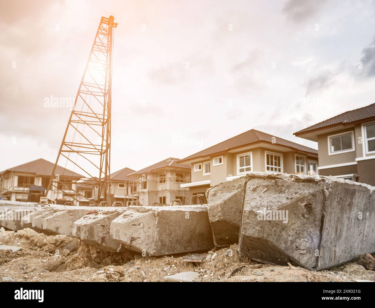 house building at construction site with pile driver and precast ...
