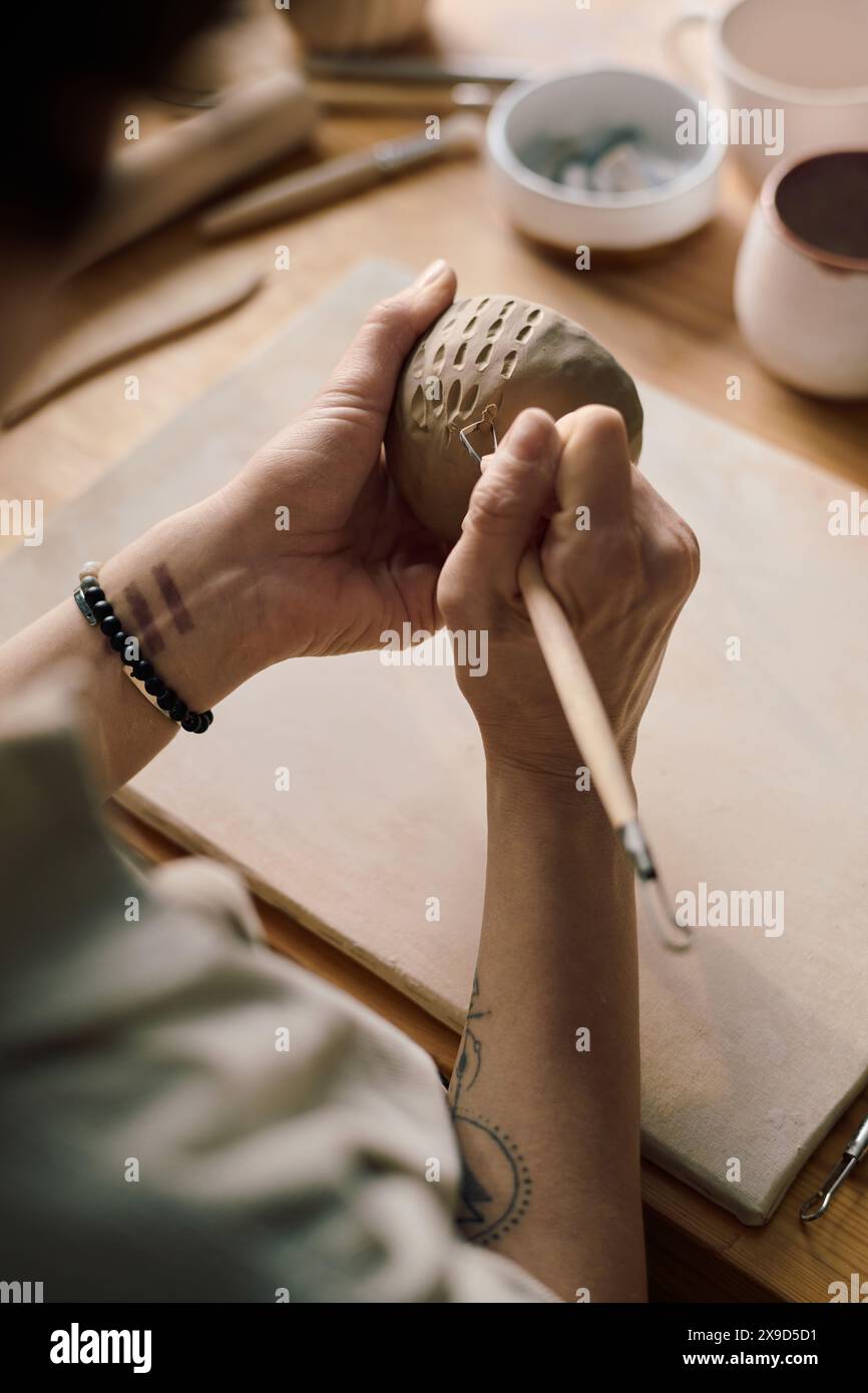 Vertical high angle shot of hands of unrecognizable artisan using clay ...